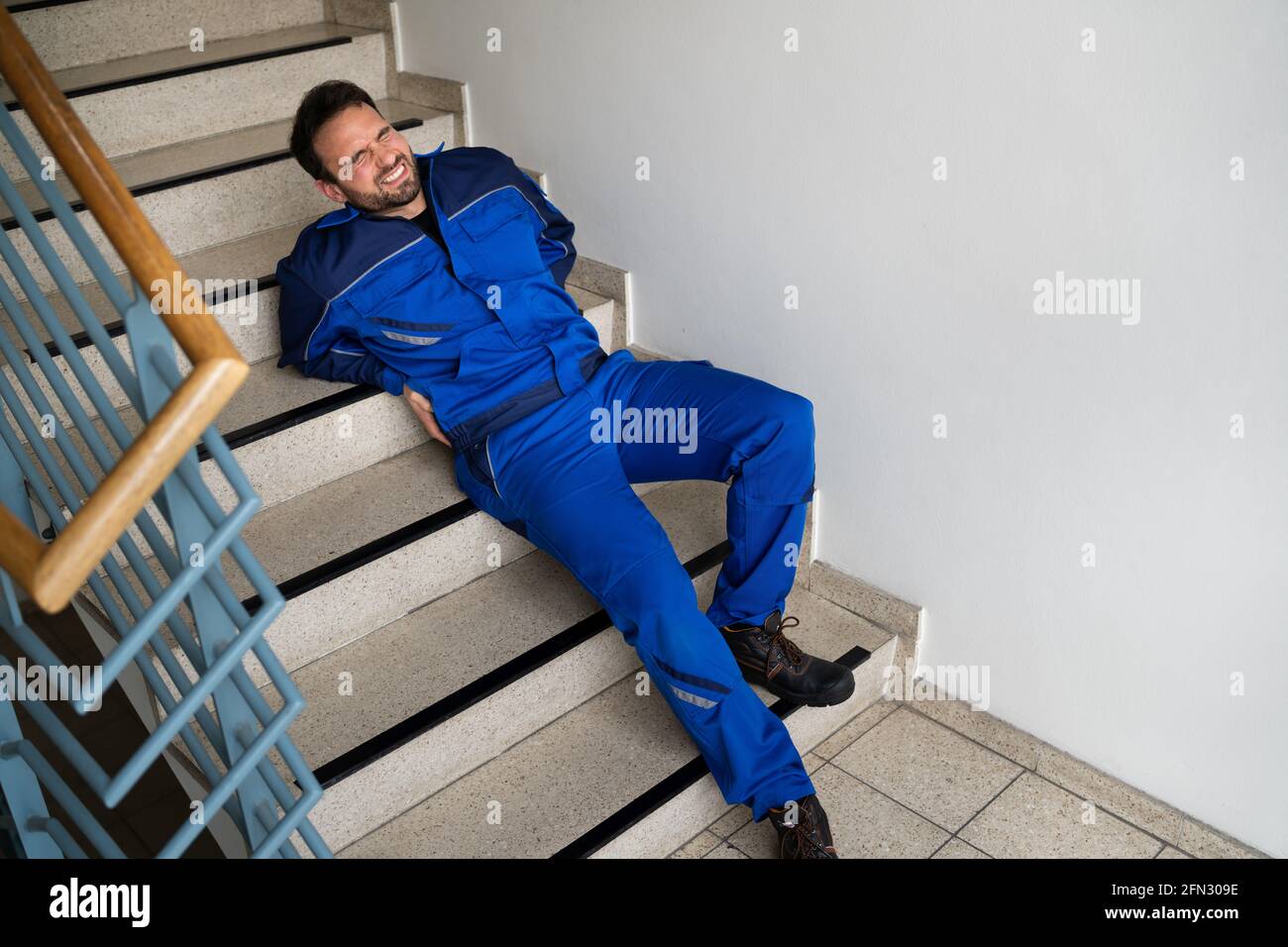 Worker Man Lying On Staircase After Slip And Fall Accident Stock Photo ...