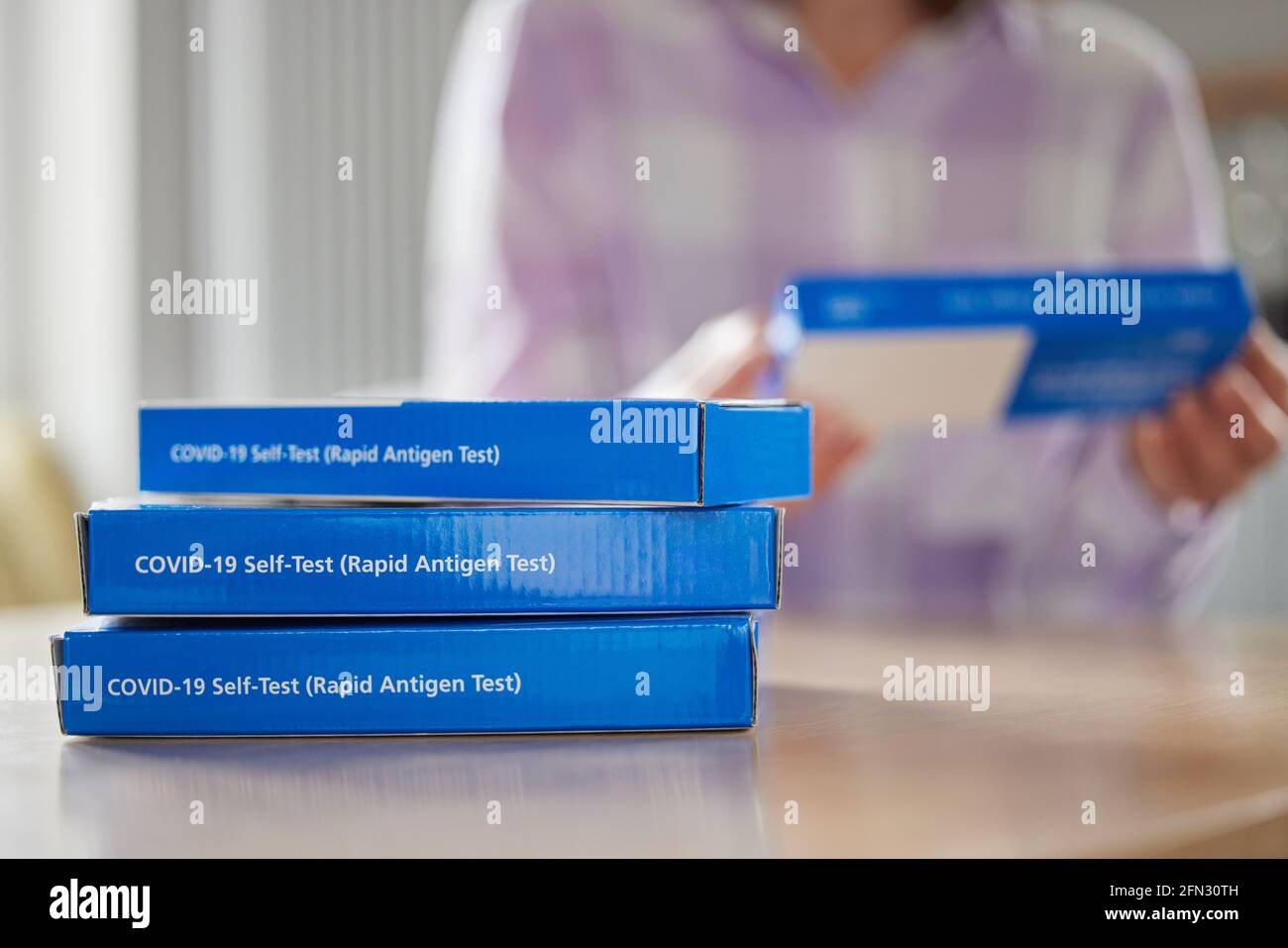 Close Up Of Woman At Home Reading Instructions On Supply Of Covid-19 ...