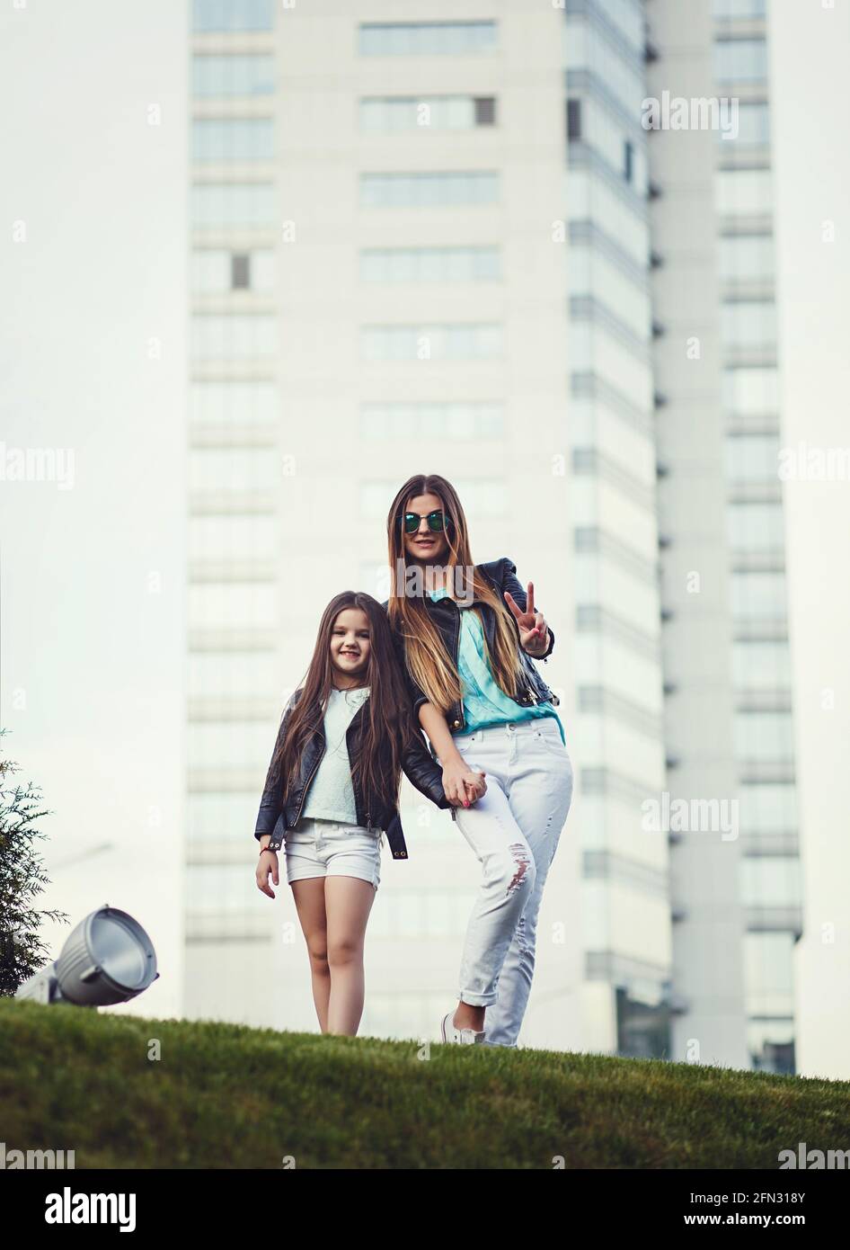 full-height portrait of mother and daughter on the background of a ...