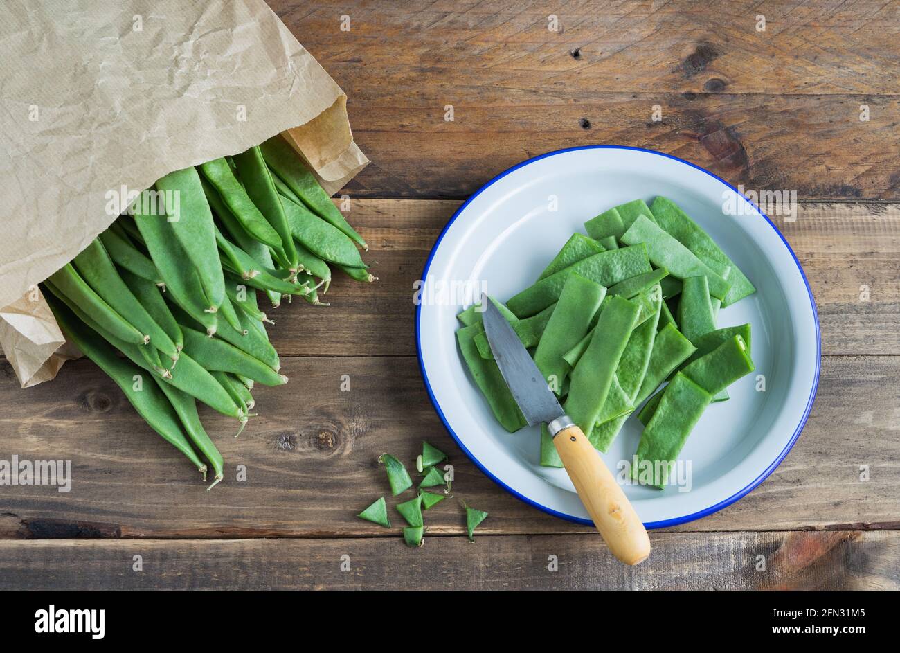Cut green beans on a plate on a rustic wooden background. Food ...