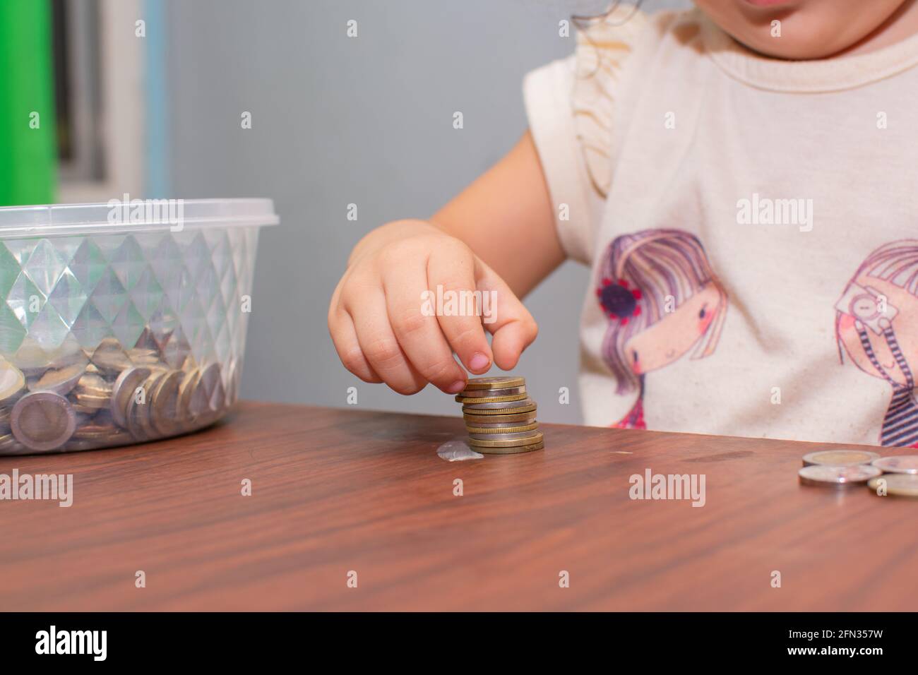 Child collecting coins in the bowl Stock Photo - Alamy