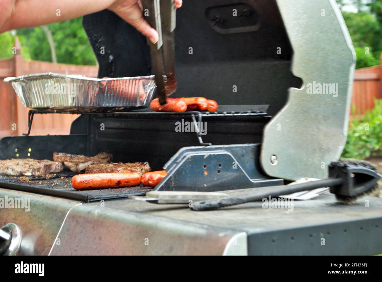 Hotdogs and steak on the grill at a backyard cookout Stock Photo - Alamy