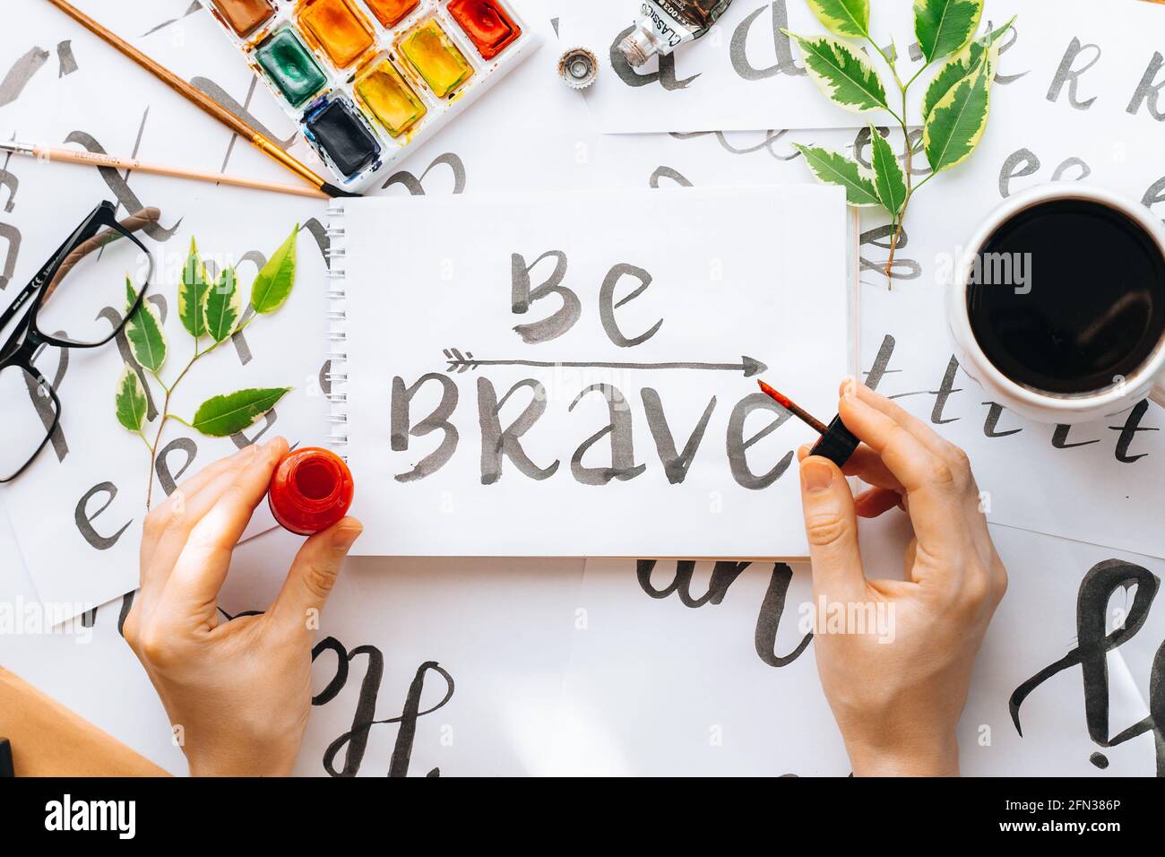 Overhead view on male man hands calligraphy sheets, nibs, paper, ink ...