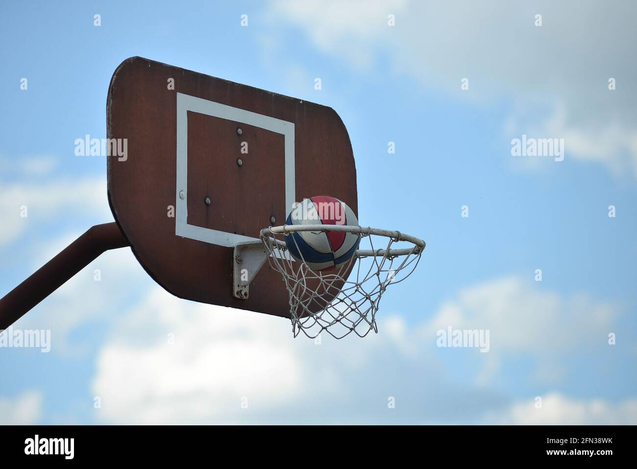 Basketball going in net on blue sky outdoors Stock Photo - Alamy