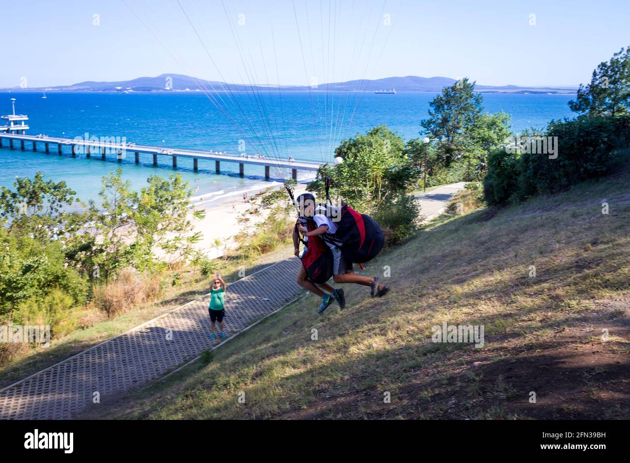 Tandem paraglider pilot prepares to take off Stock Photo - Alamy