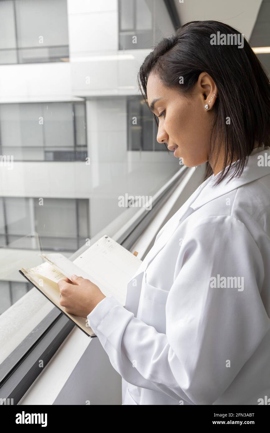 beautiful brunette young female doctor with short hair, standing ...