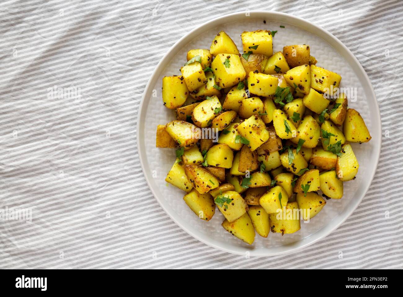 Homemade Roasted Potatoes with Mustard Seeds on a Plate, overhead view ...
