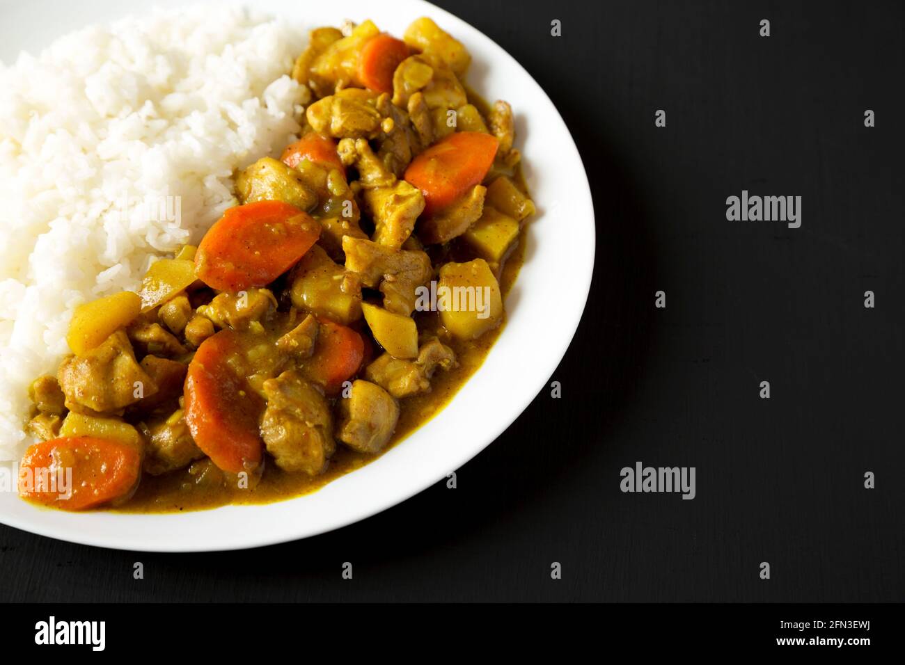 Homemade Japanese Chicken Curry on a white plate on a black background ...