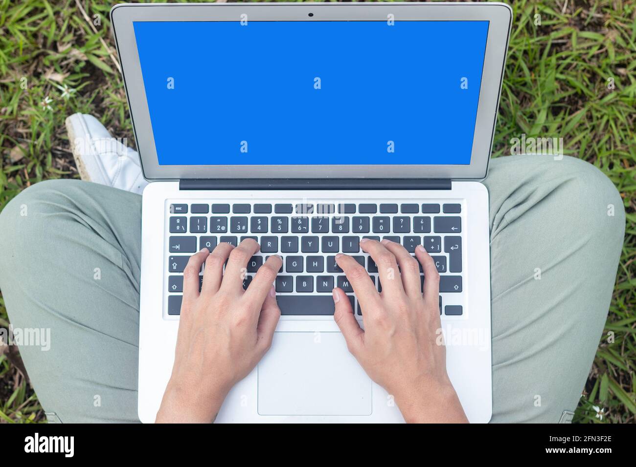 Top view of a female typing on a laptop with a blue screen Stock Photo ...