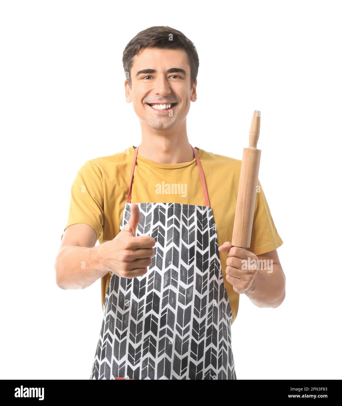 Young man with rolling pin showing thumb-up on white background Stock ...
