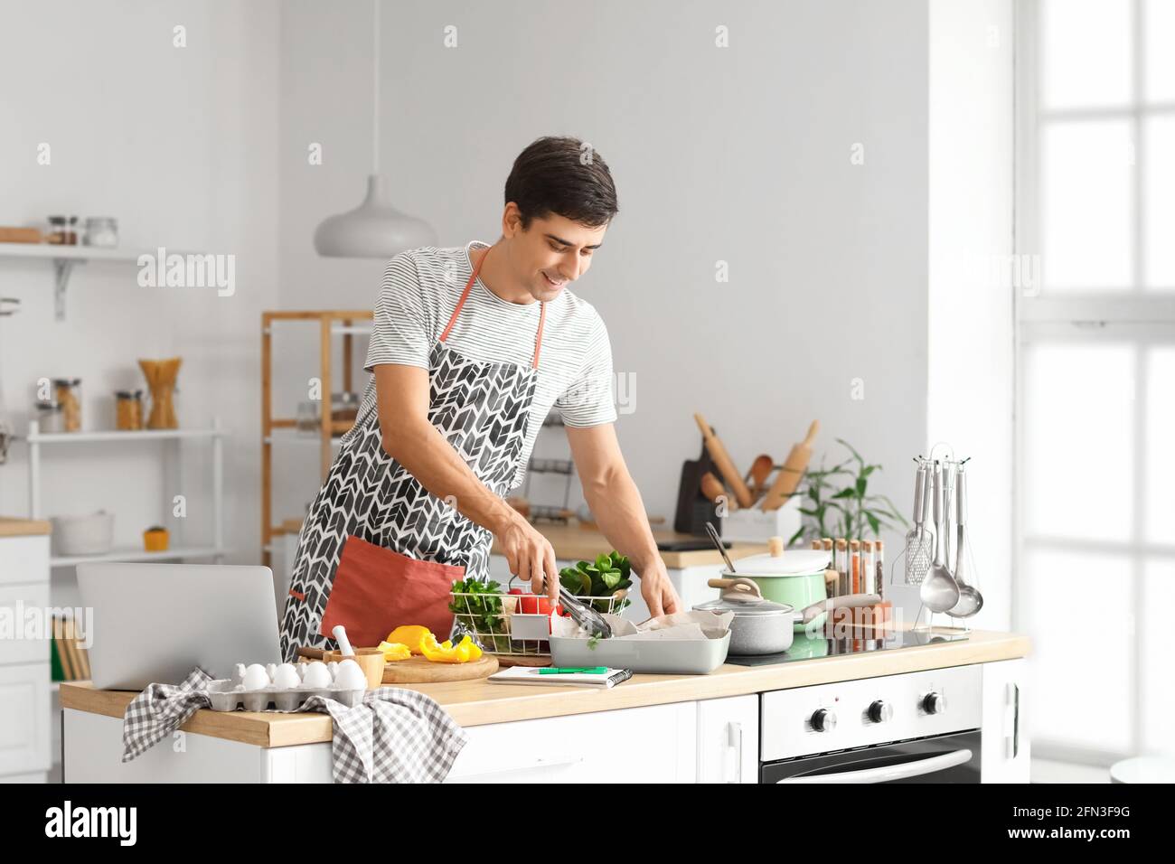 Young man cooking in kitchen Stock Photo - Alamy
