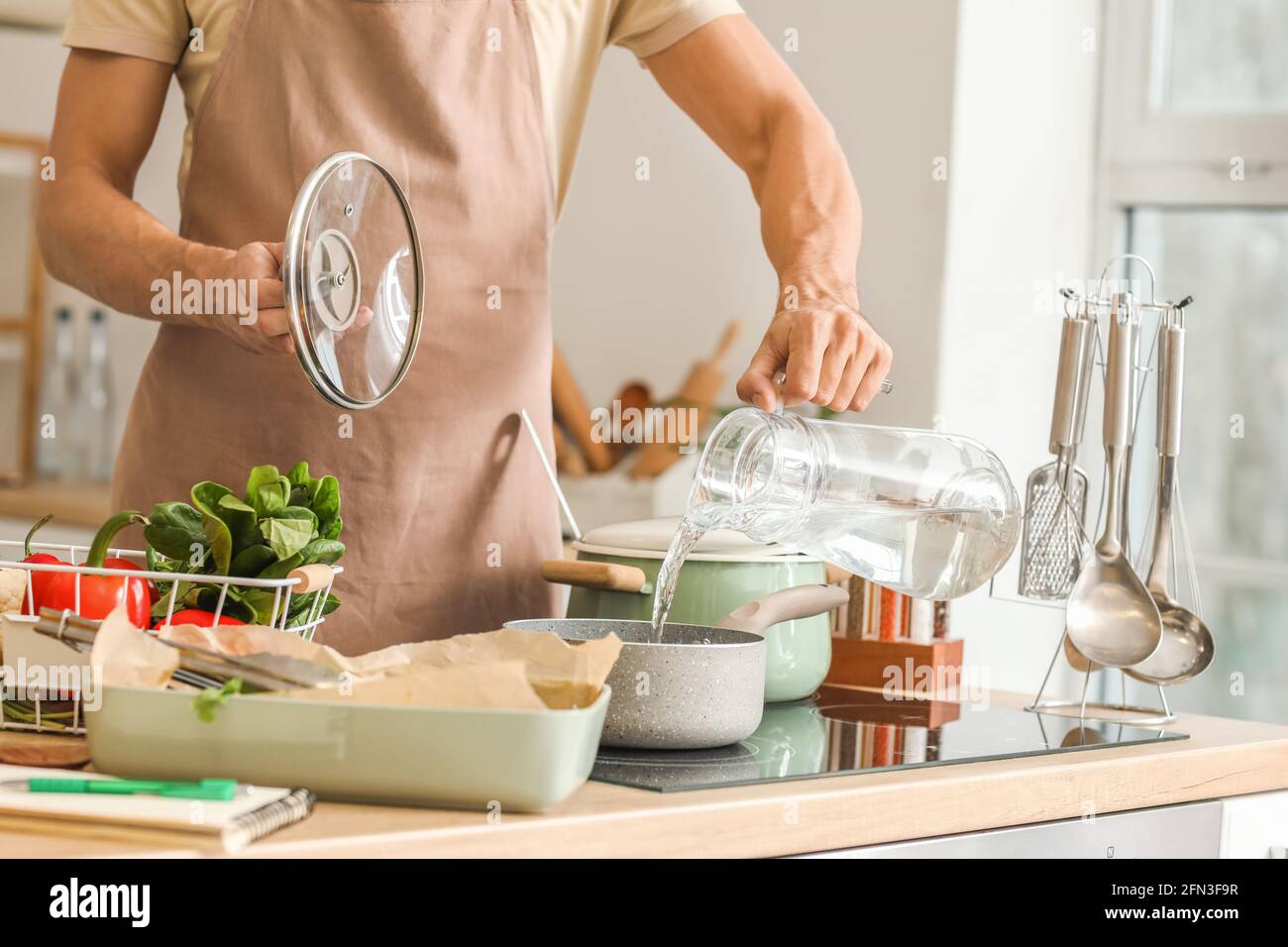 Young man cooking in kitchen Stock Photo - Alamy