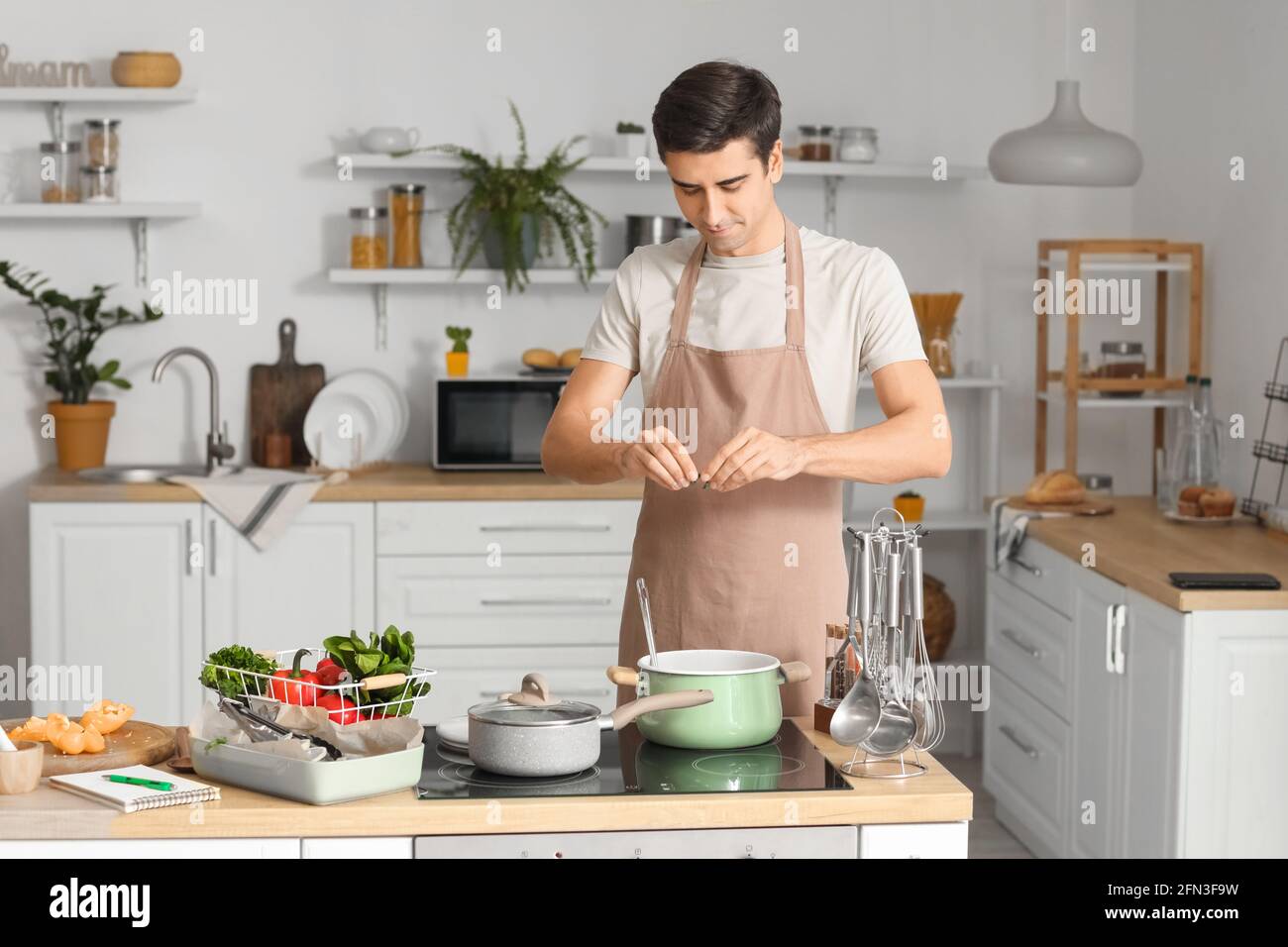 Young man cooking in kitchen Stock Photo - Alamy