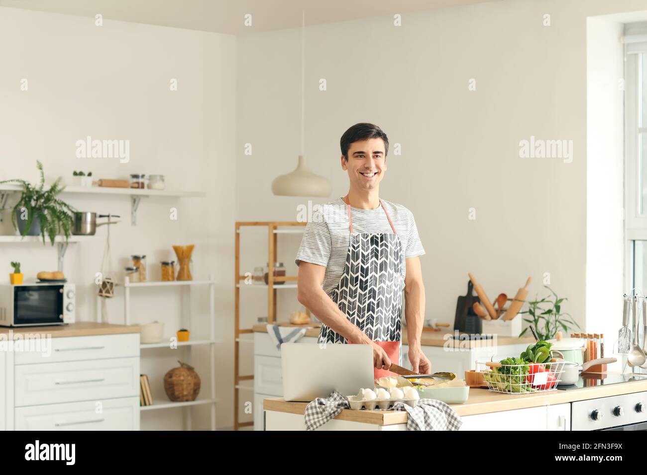 Young man cooking in kitchen Stock Photo - Alamy