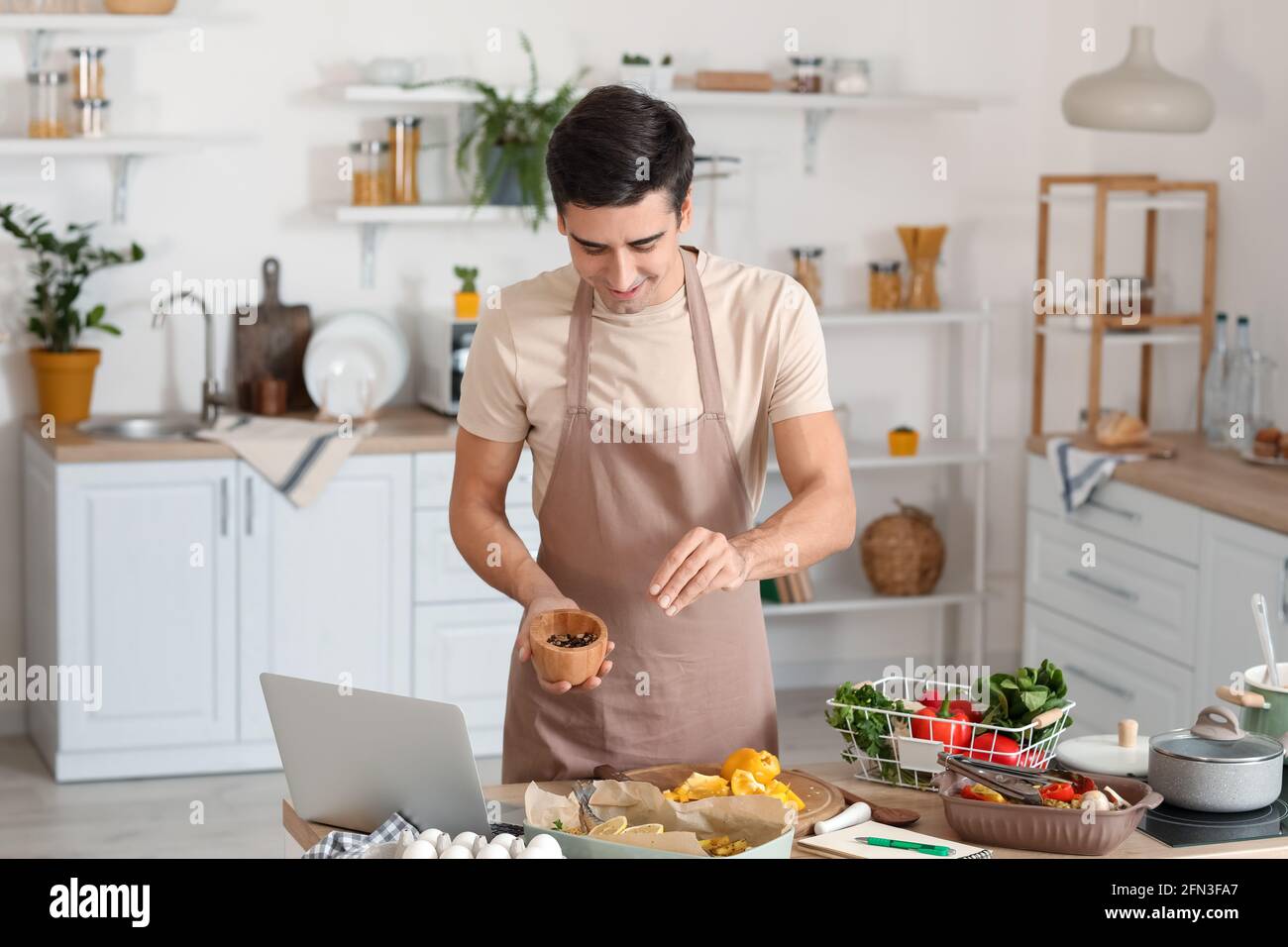Young man cooking in kitchen Stock Photo - Alamy