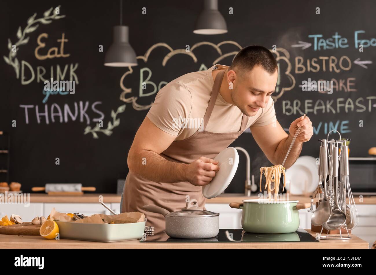 Young man cooking in kitchen Stock Photo - Alamy
