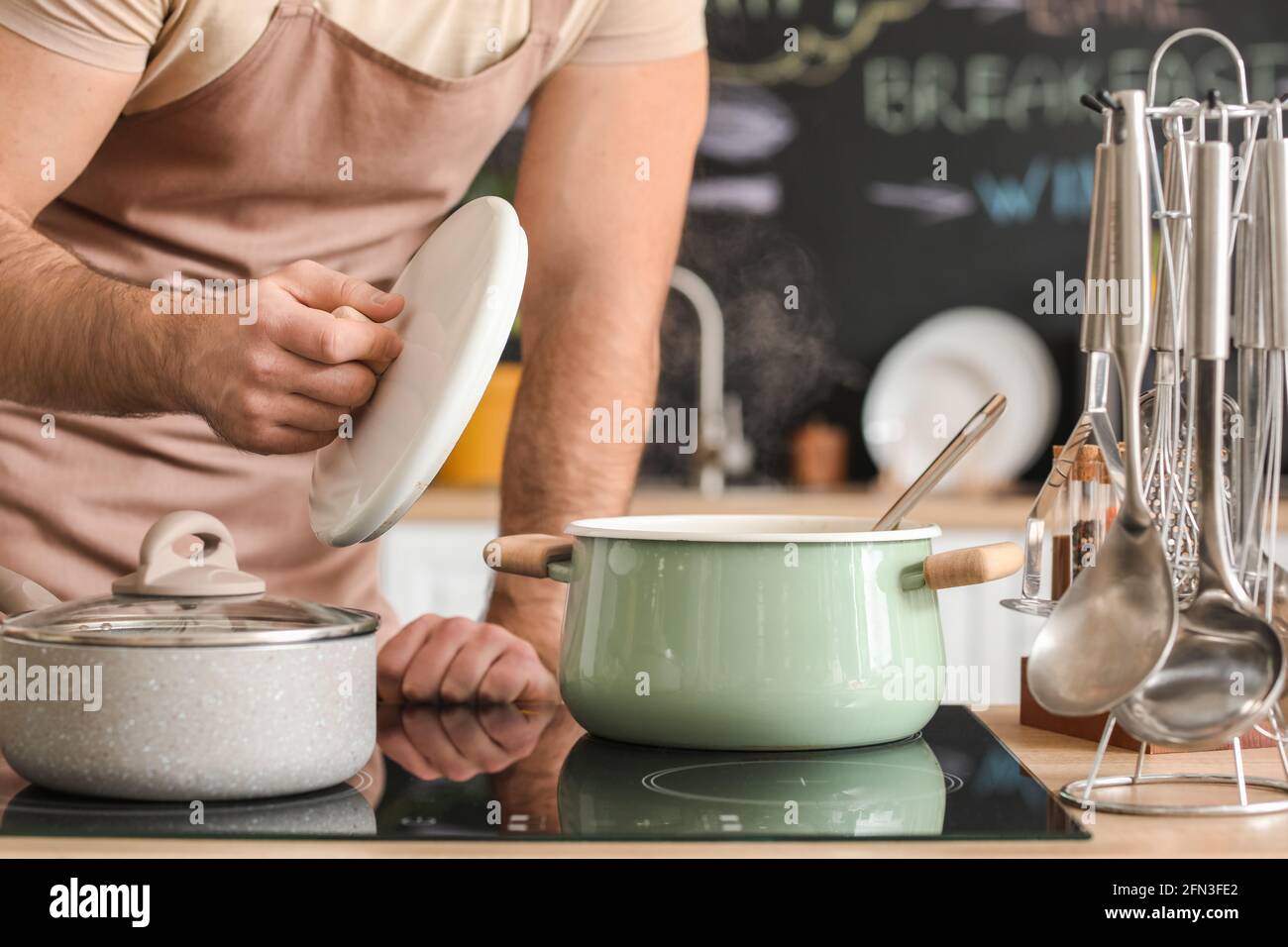 Young man cooking in kitchen Stock Photo - Alamy