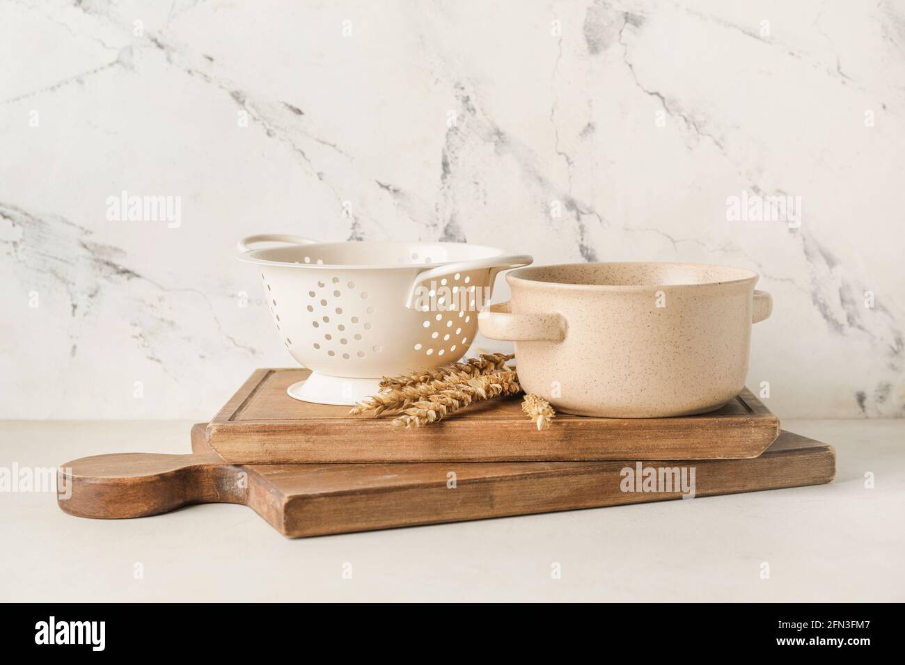 Cooking pot with colander and chopping boards on light background Stock ...