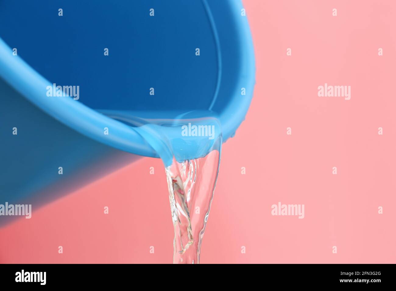 Pouring of water from bucket on color background, closeup Stock Photo ...