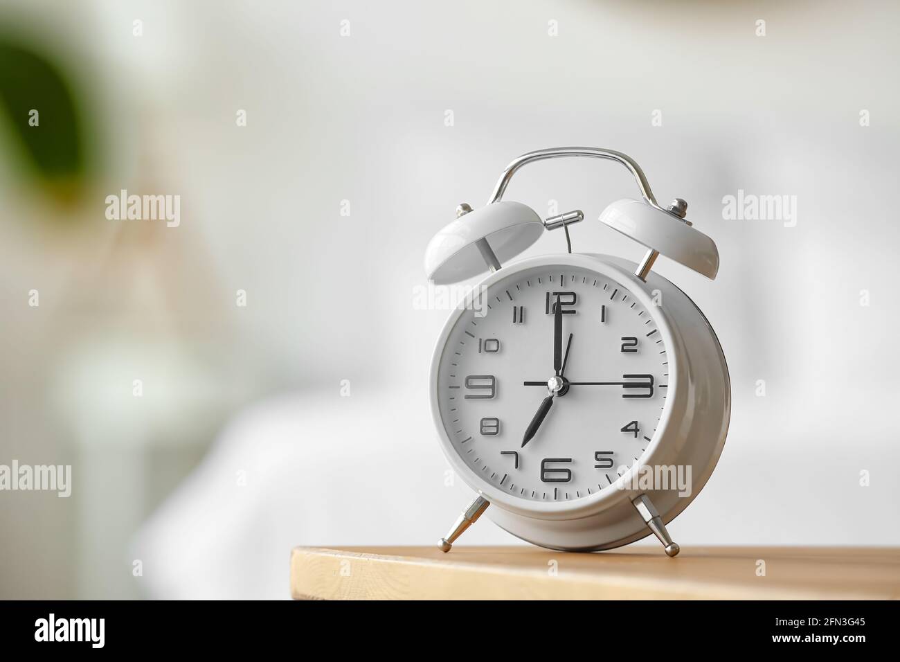Alarm clock on table in bedroom Stock Photo - Alamy
