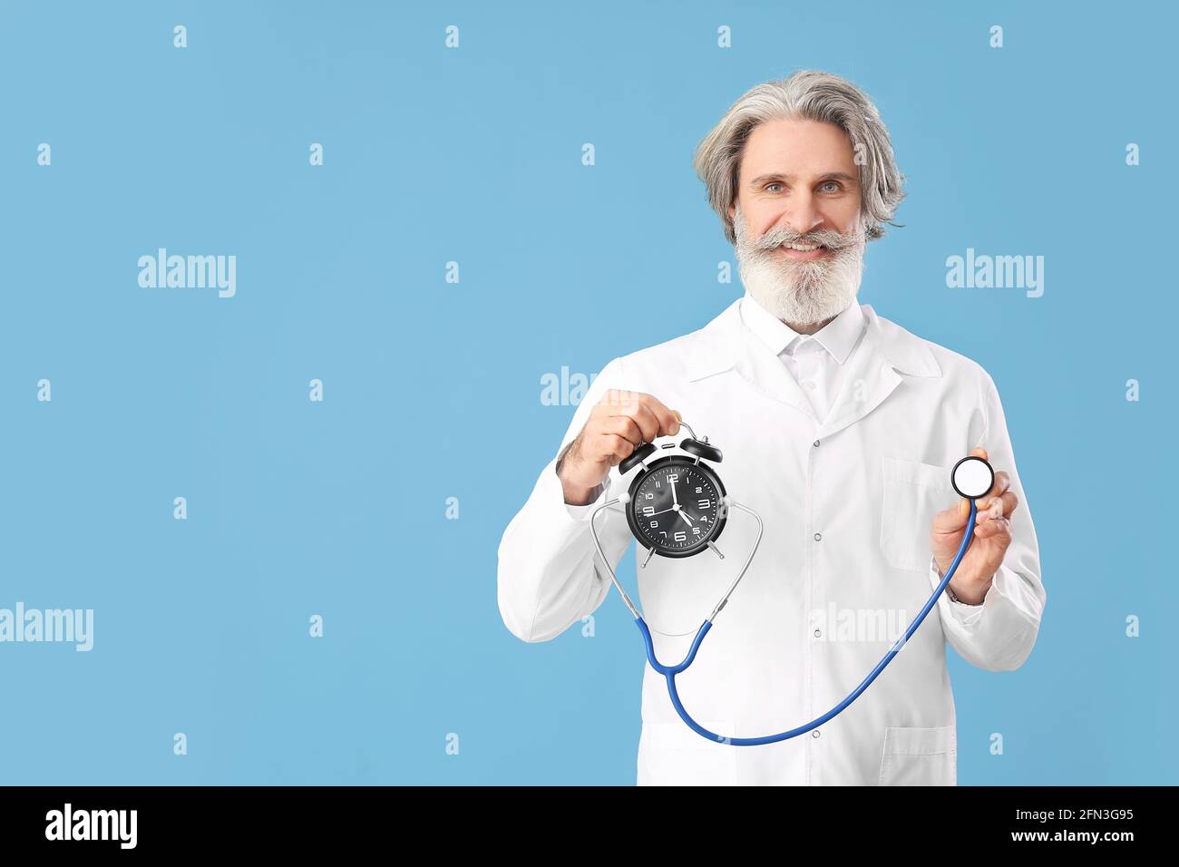 Doctor with alarm clock and stethoscope on color background Stock Photo ...