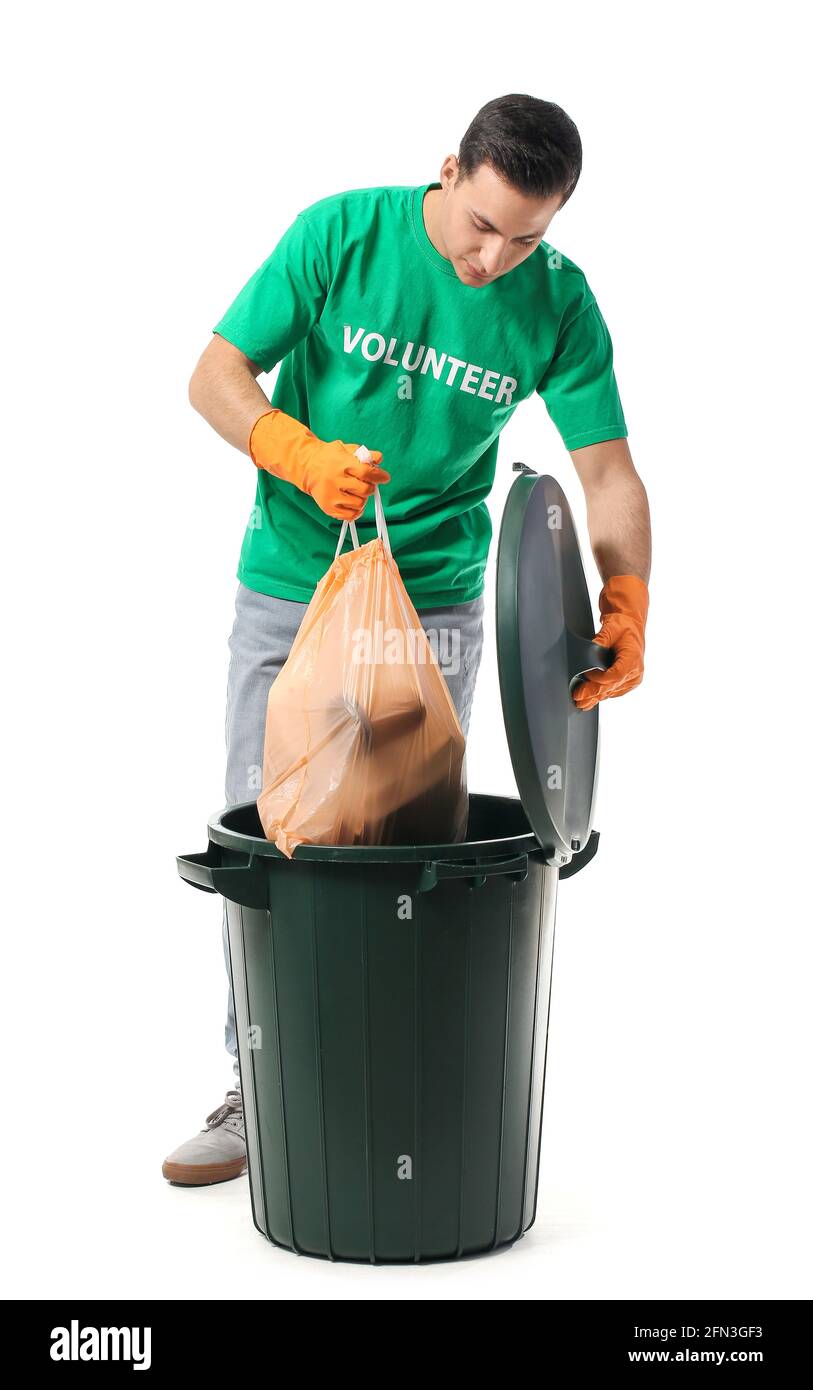Male volunteer putting garbage in trash bin on white background Stock ...