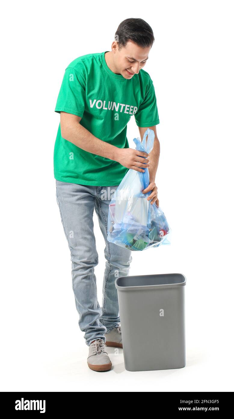 Male volunteer putting garbage in trash bin on white background Stock ...