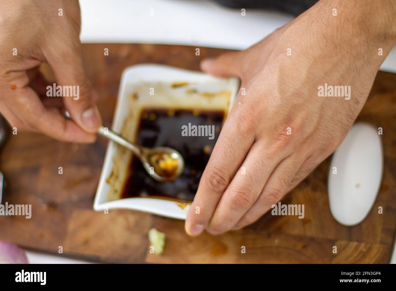 Top view of a man making a soy sauce in a white plate Stock Photo - Alamy
