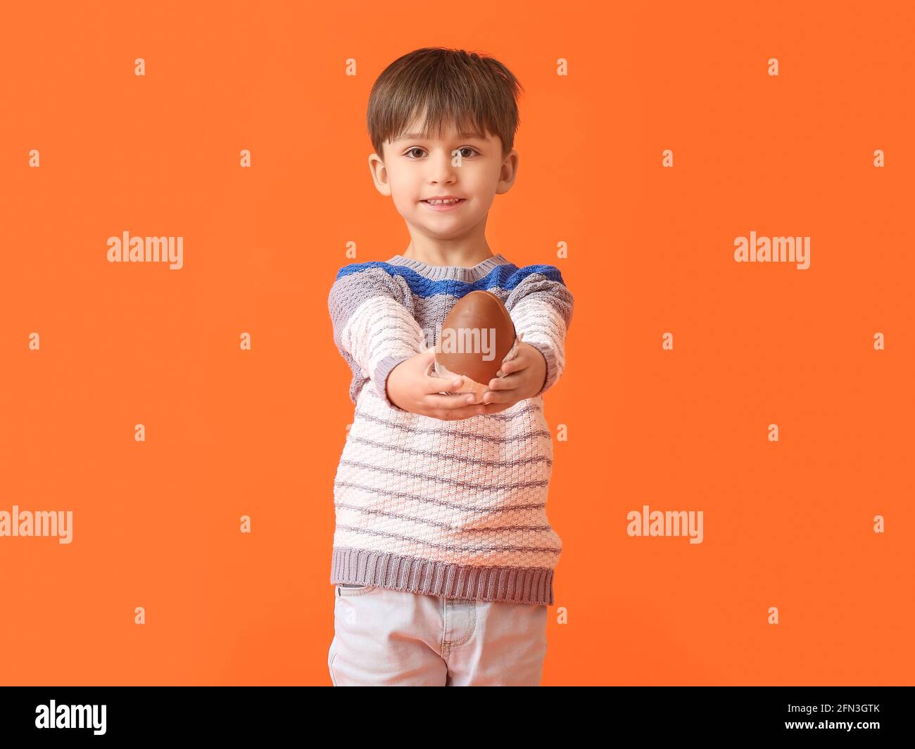 Cute little boy with chocolate Easter egg on color background Stock ...