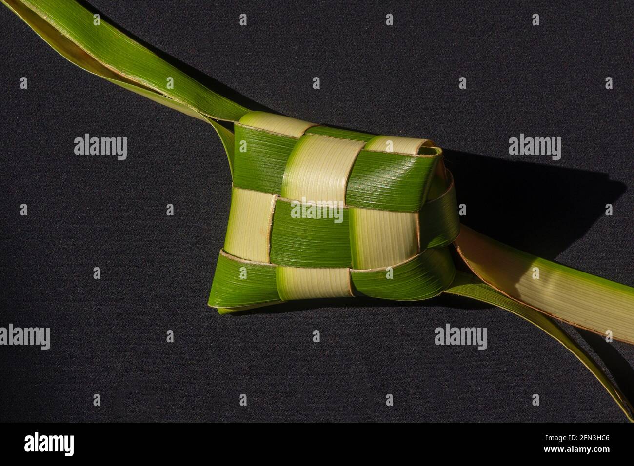 Ketupat Lebaran, a rice cake packed inside a diamond shaped container ...