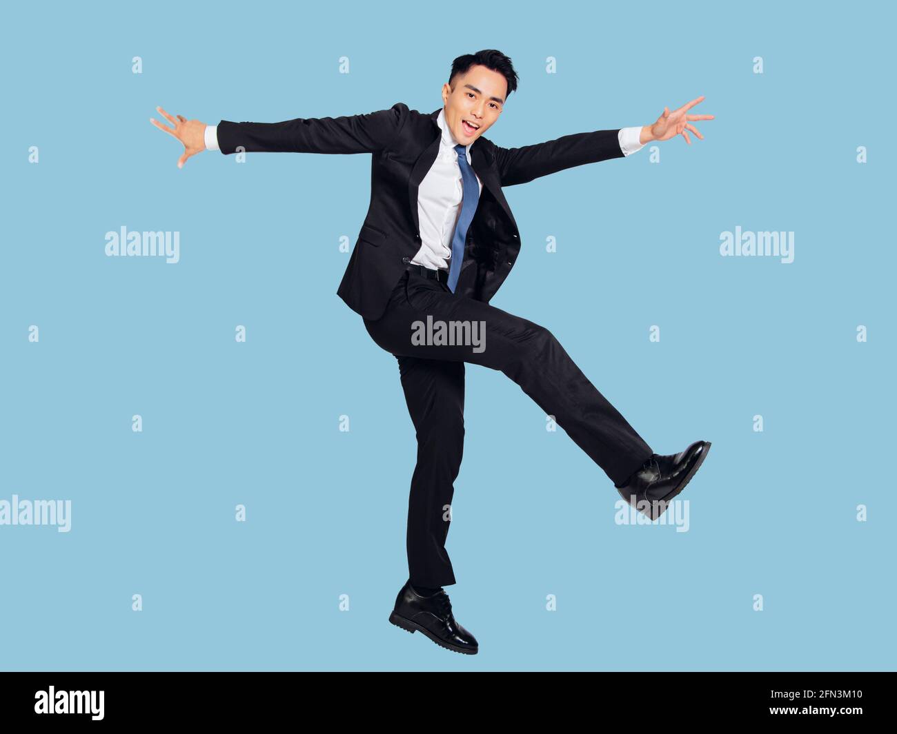 Excited young businessman jumping and dancing Stock Photo - Alamy