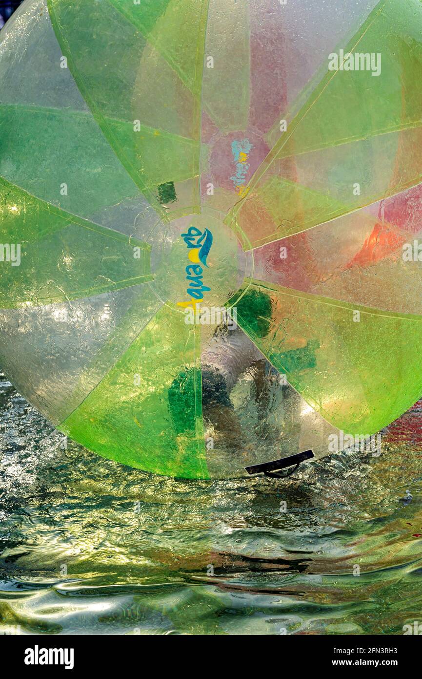 Children playing on an inflatable water waking ride (Zorb ball) at the ...