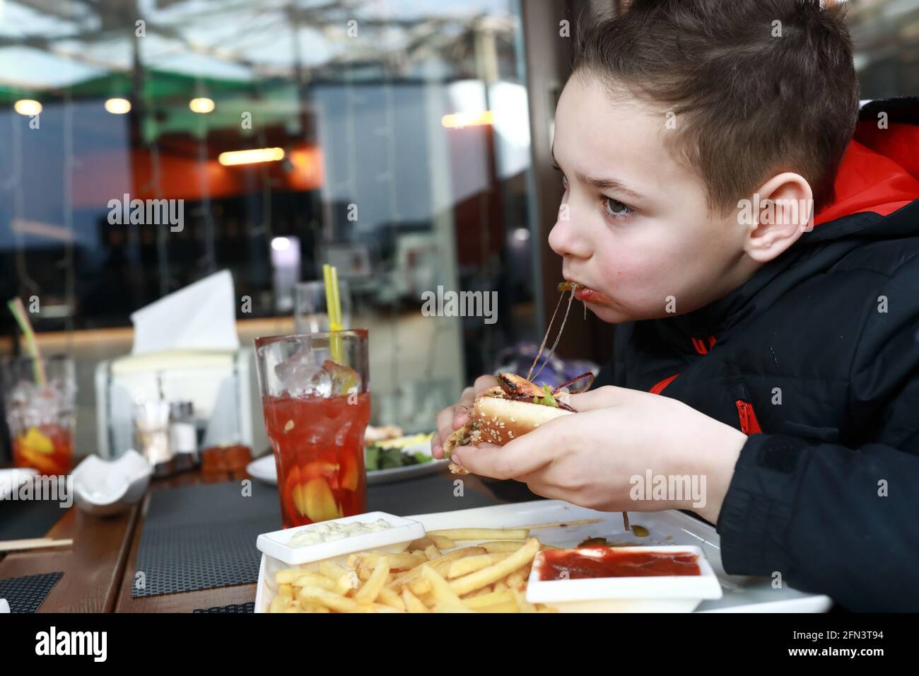 Boy biting into burger hi-res stock photography and images - Alamy