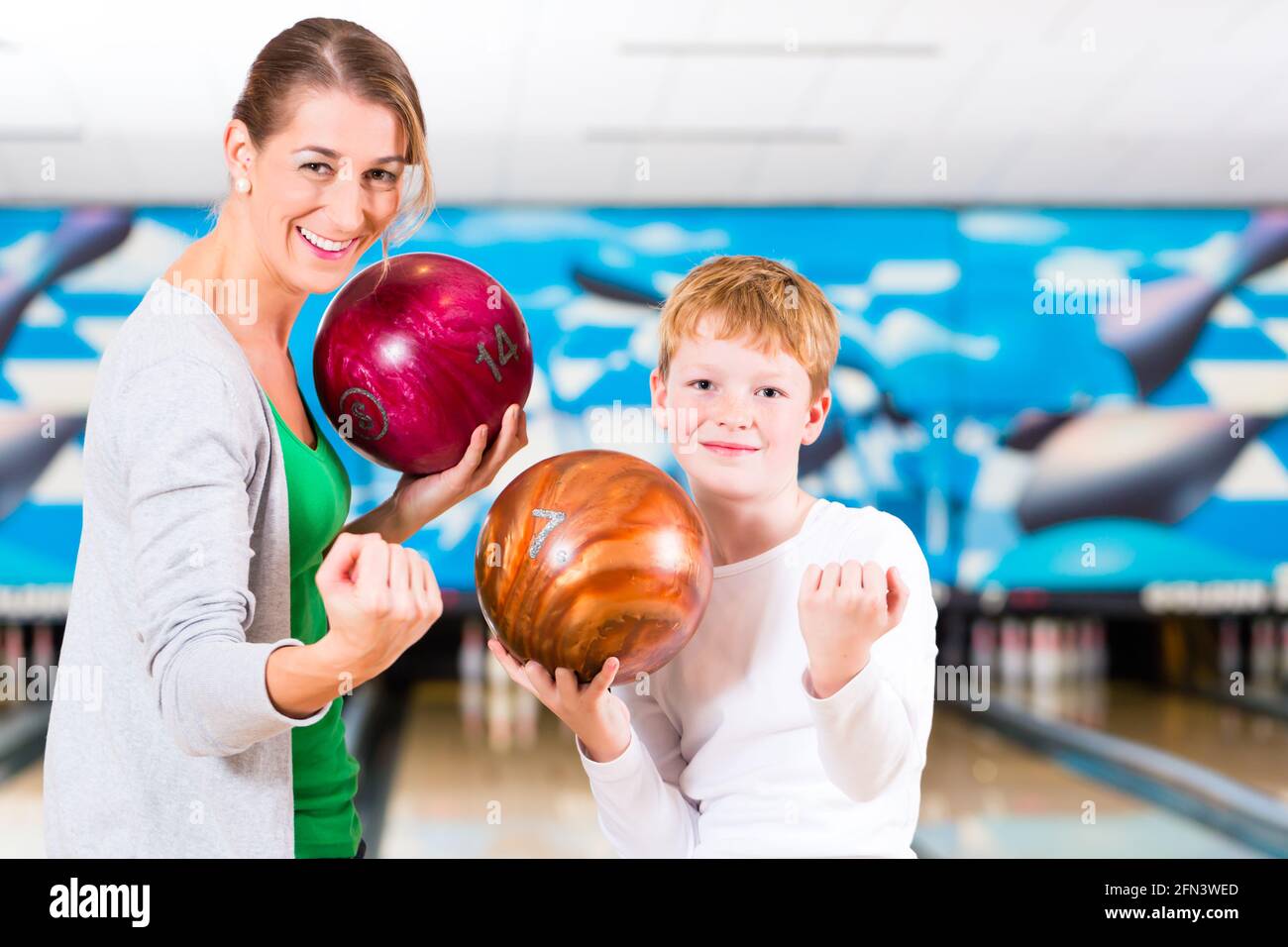 Happy mother and son playing together at bowling center Stock Photo - Alamy