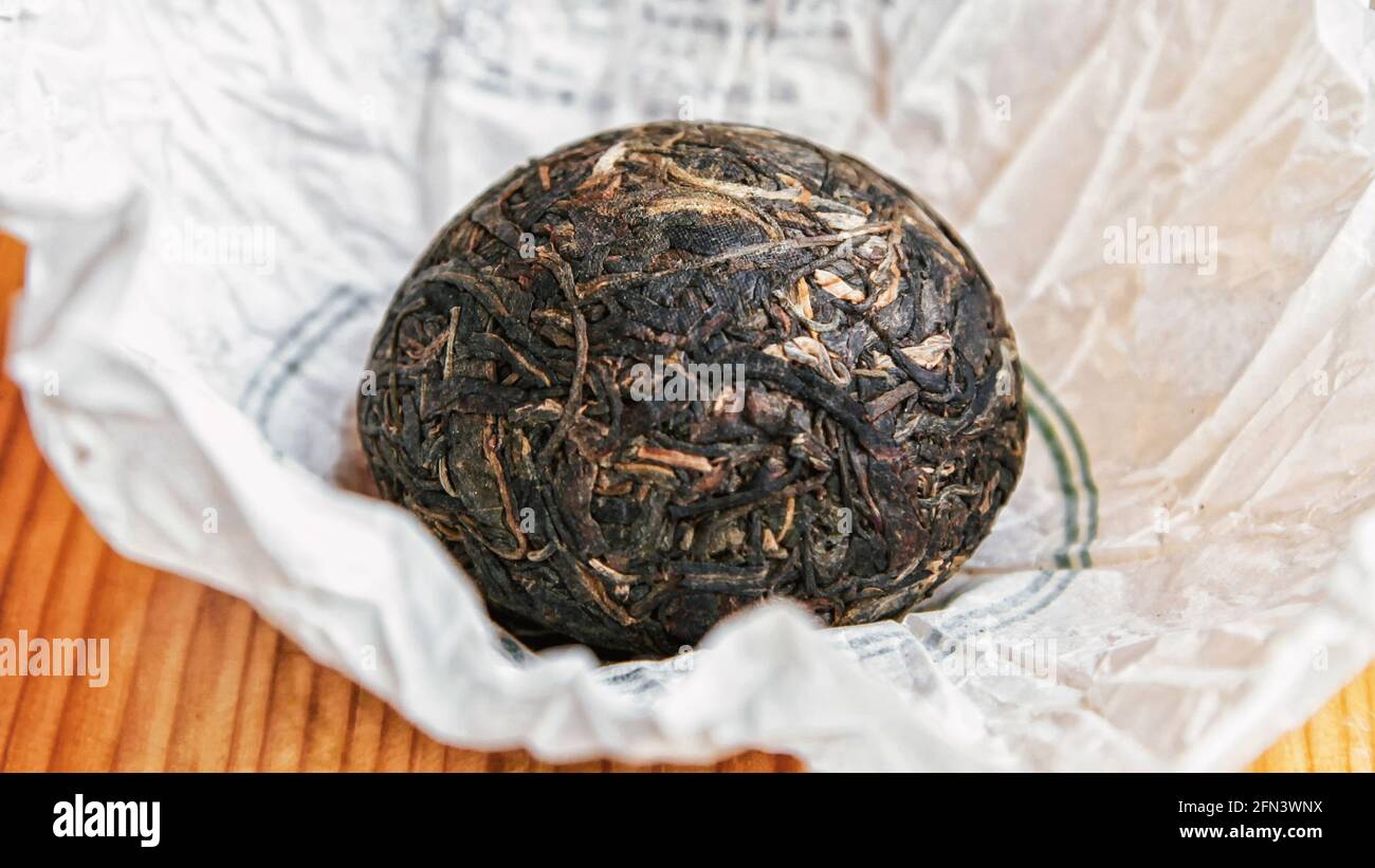 Chinese Raw Pu Er tea in the form of a nest in a paper wrapper Stock ...