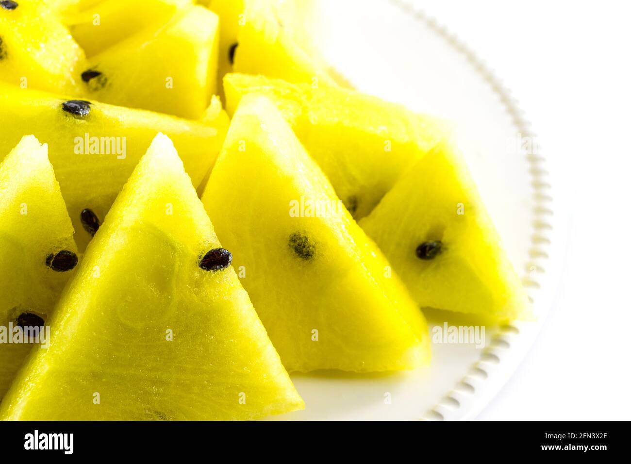 Slices of yellow watermelon on white disk on white background Stock ...