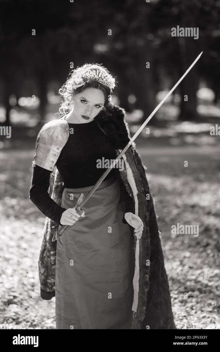 Armed medieval woman warrior in armor posing while standing on ...