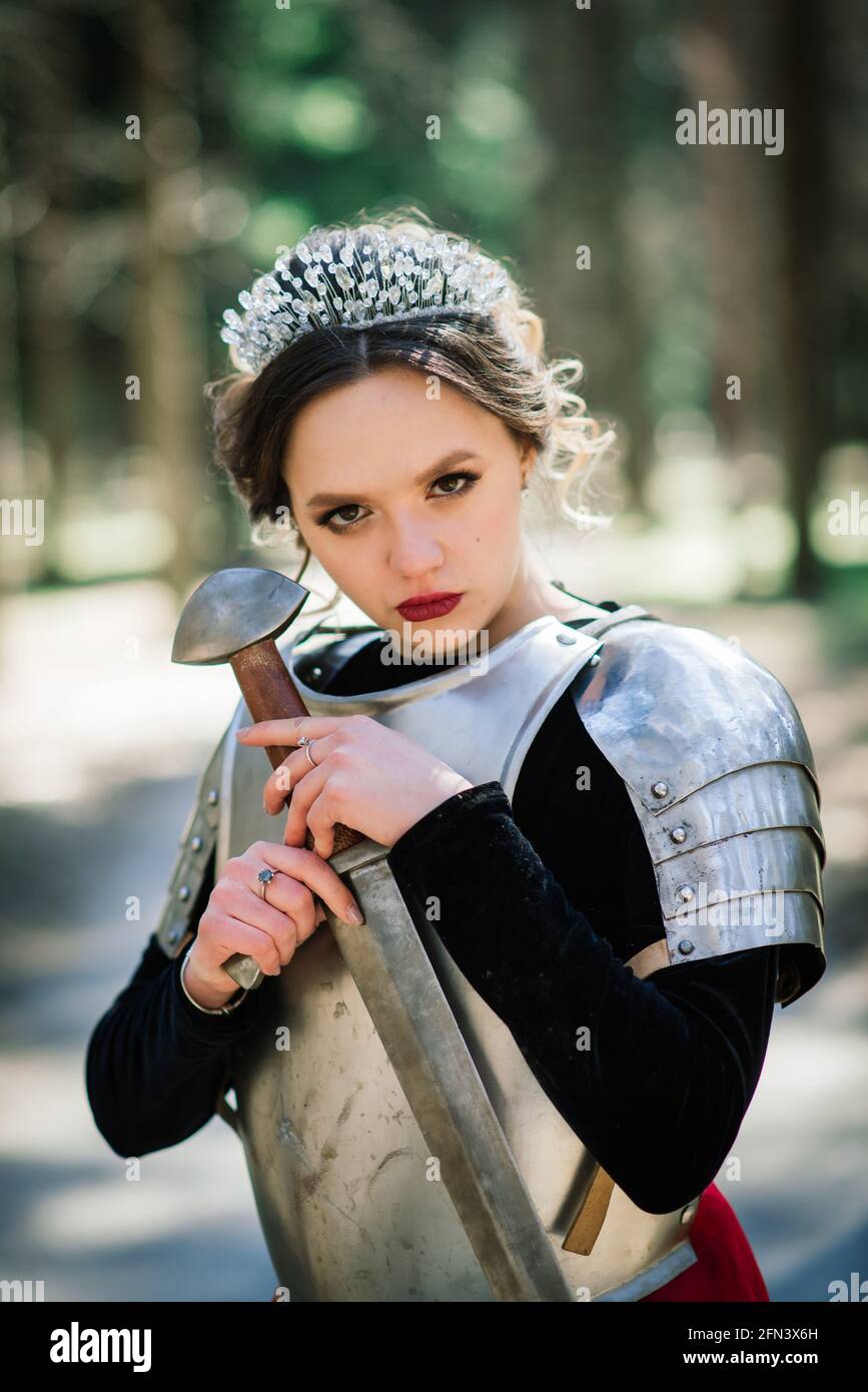 Armed medieval woman warrior in armor posing while standing on ...