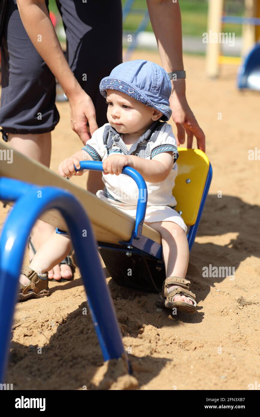 Child is swinging on the seesaw at a playground Stock Photo - Alamy