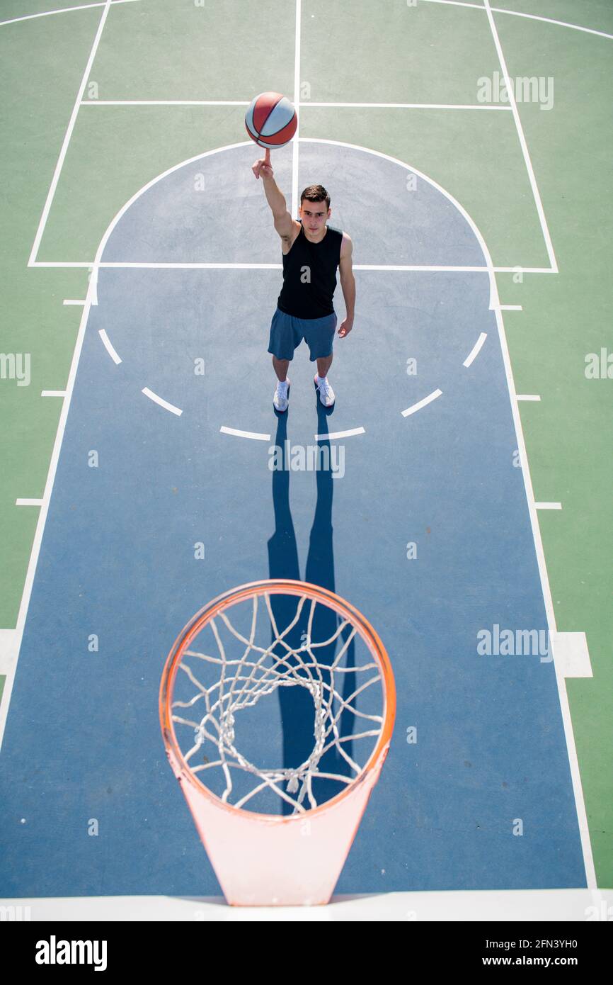 Angle view of man playing basketball, above hoop of man shooting ...