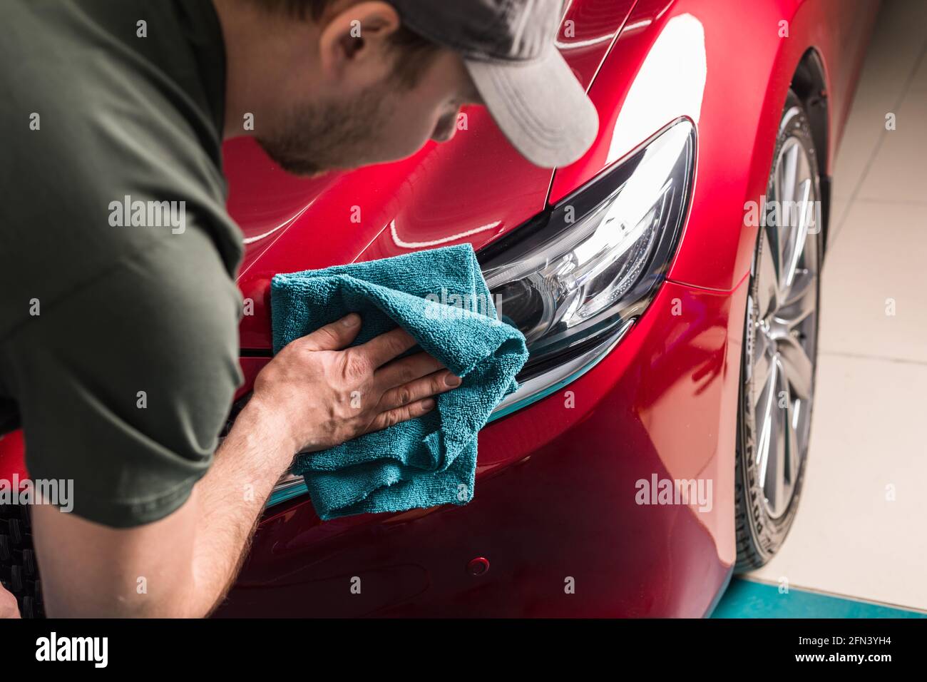 Polishing the headlight of a red car Stock Photo - Alamy