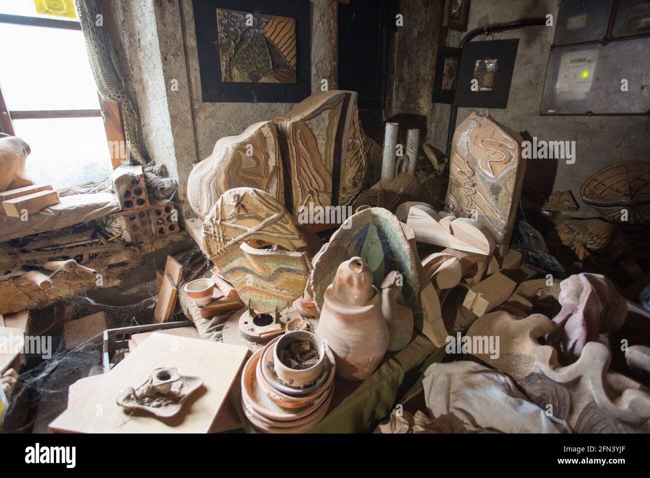 Ceramic artist artwork in old pottery workshop with cobwebbed windows ...