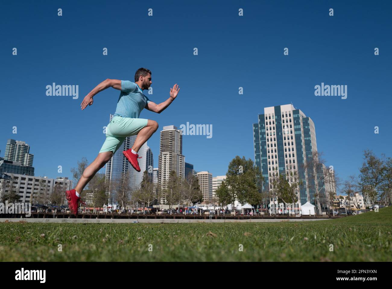 Full length of healthy man running and sprinting outdoors near city ...