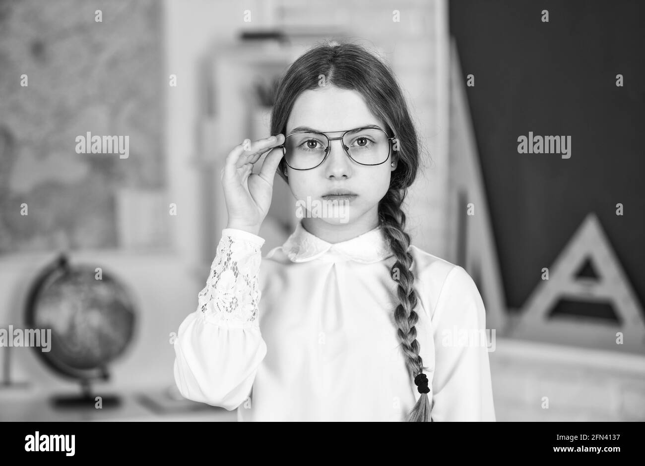 smart look. Small child girl posing in school at lesson. Learning ...
