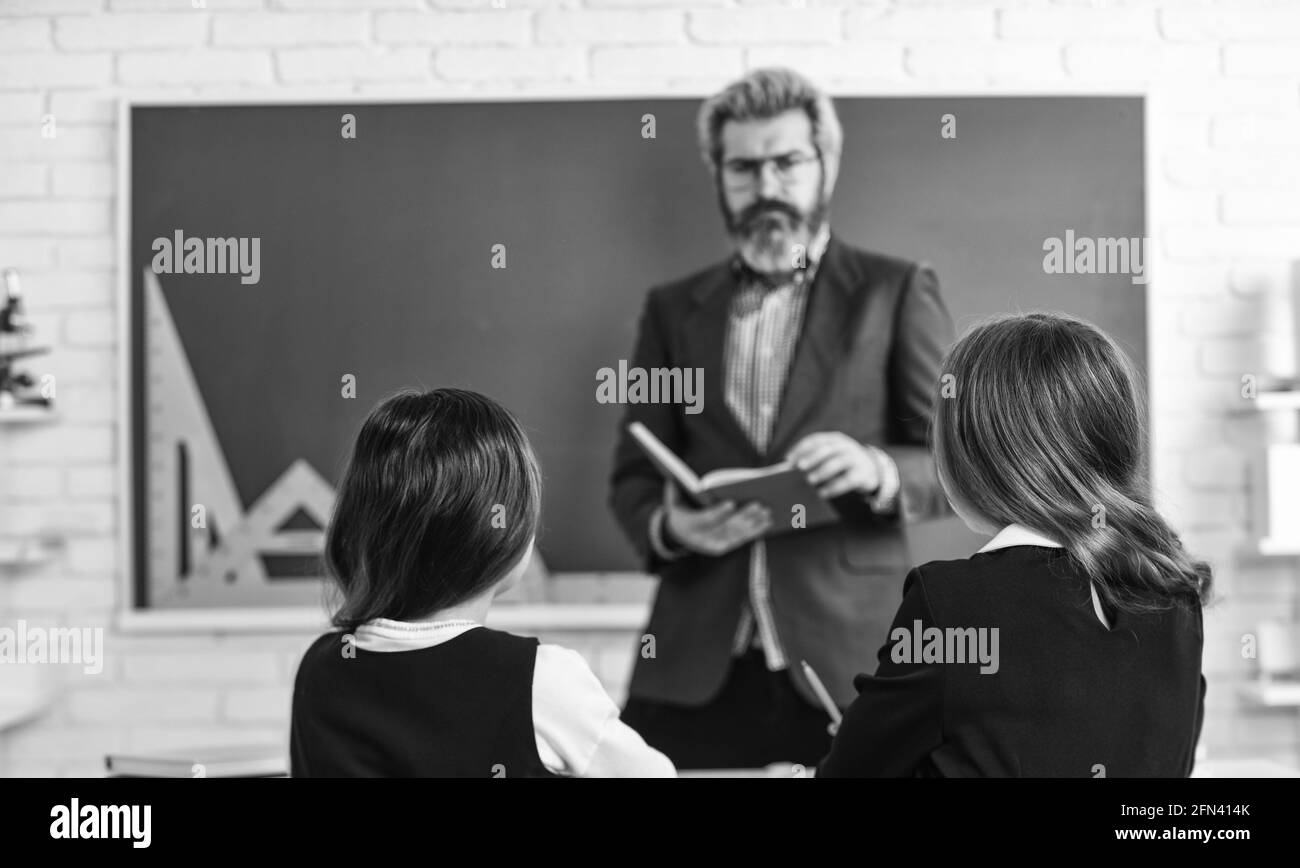 Elementary School Teacher Giving Support In Classroom. Pupil Wearing ...