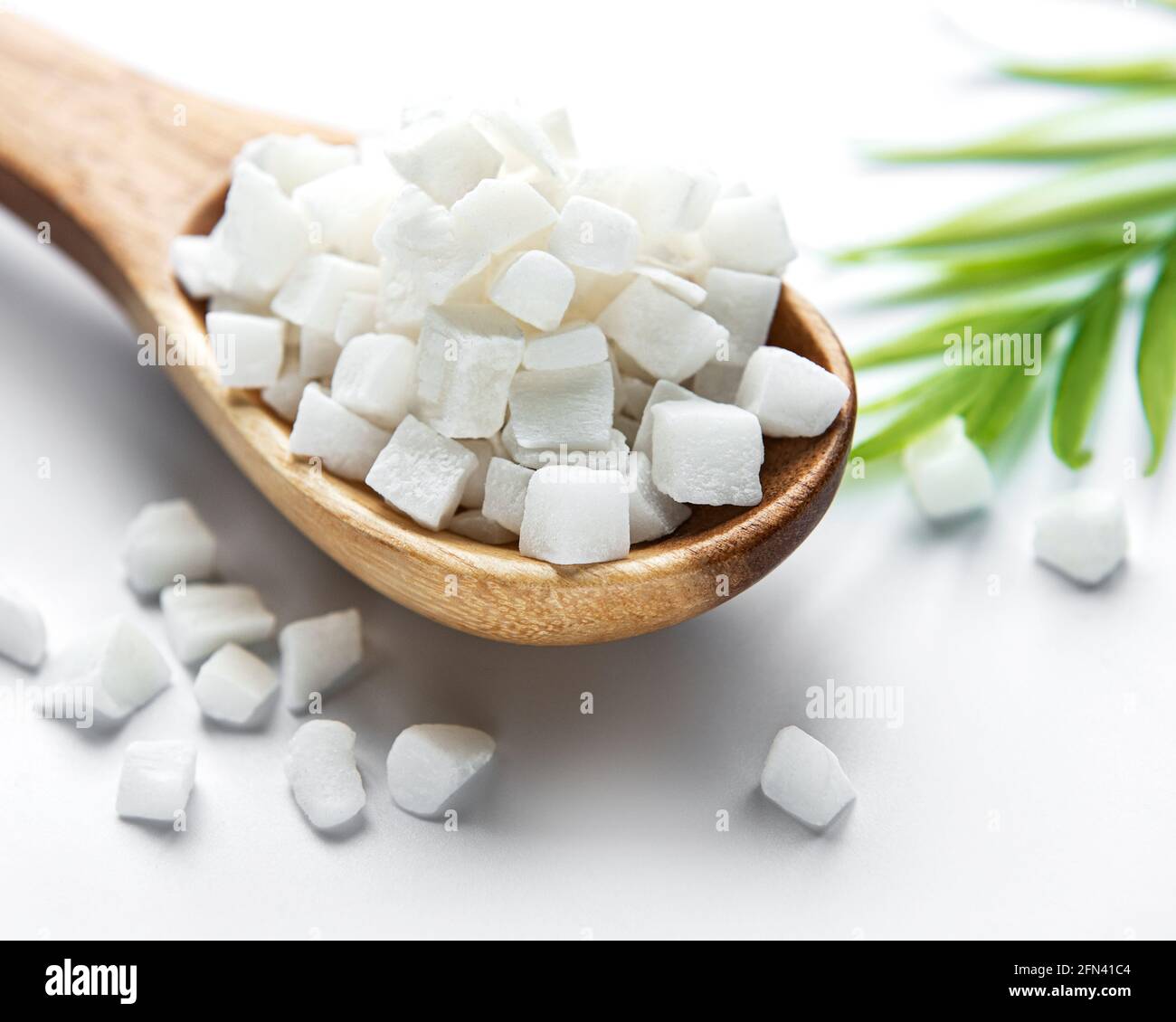Dried sweet coconut cubes in spoon on white background Stock Photo - Alamy