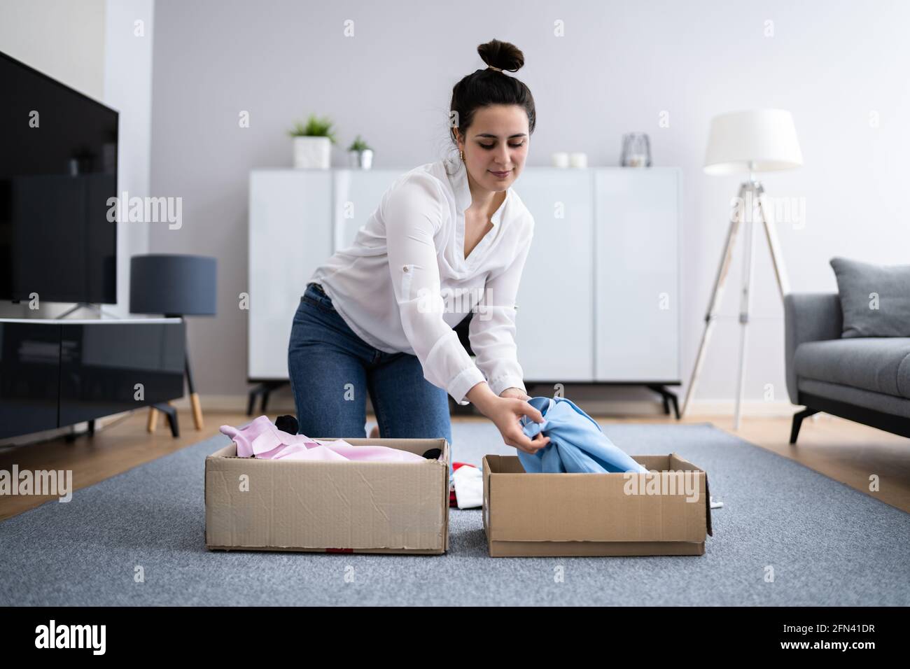 Woman Decluttering Clothes, Sorting And Cleaning Up Stock Photo - Alamy