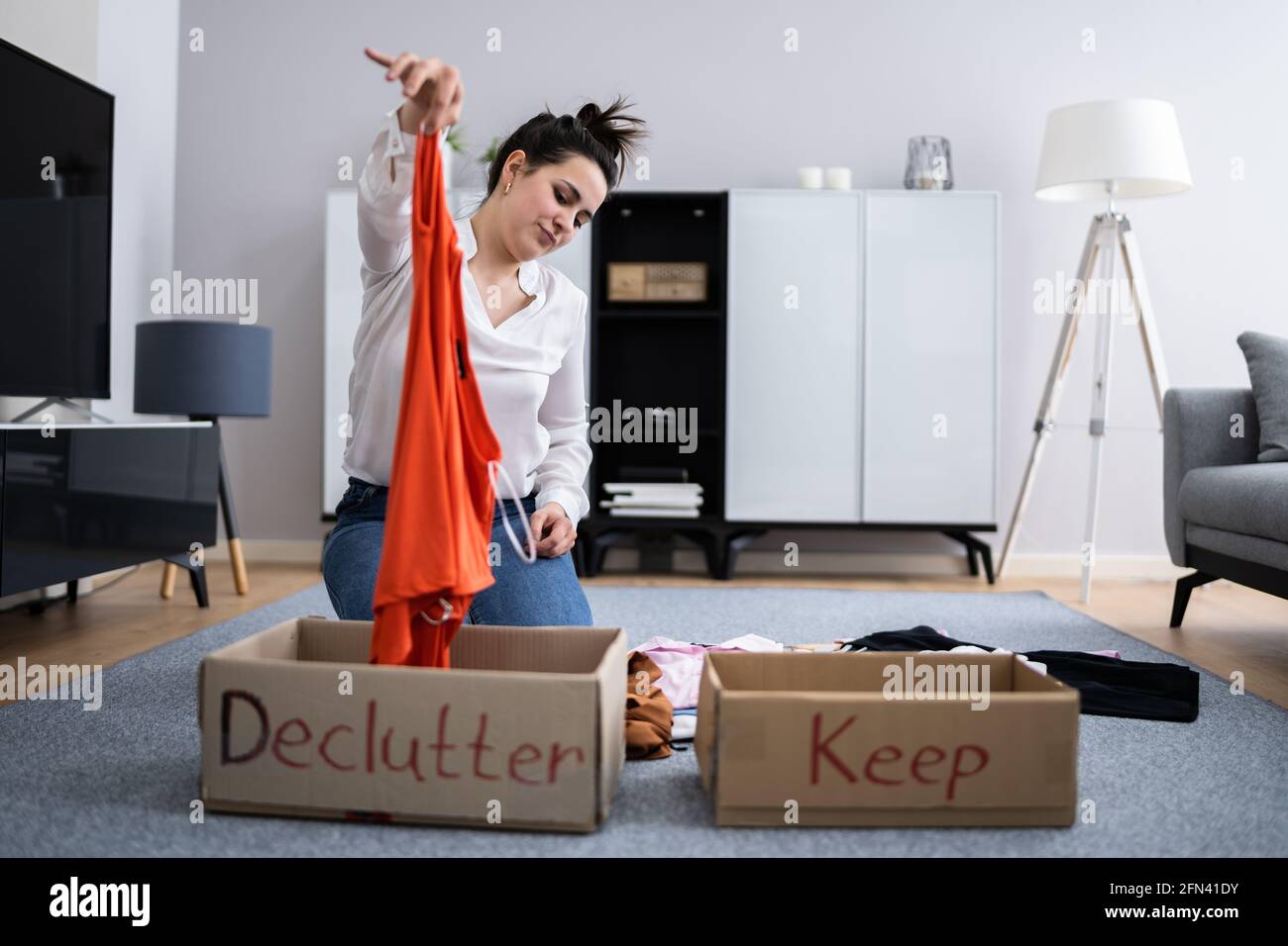 Woman Decluttering Clothes, Sorting And Cleaning Up Stock Photo - Alamy