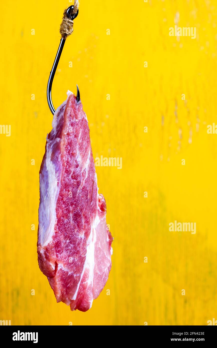 Baited hook. A piece of meat on a hook. Raw meat Stock Photo - Alamy