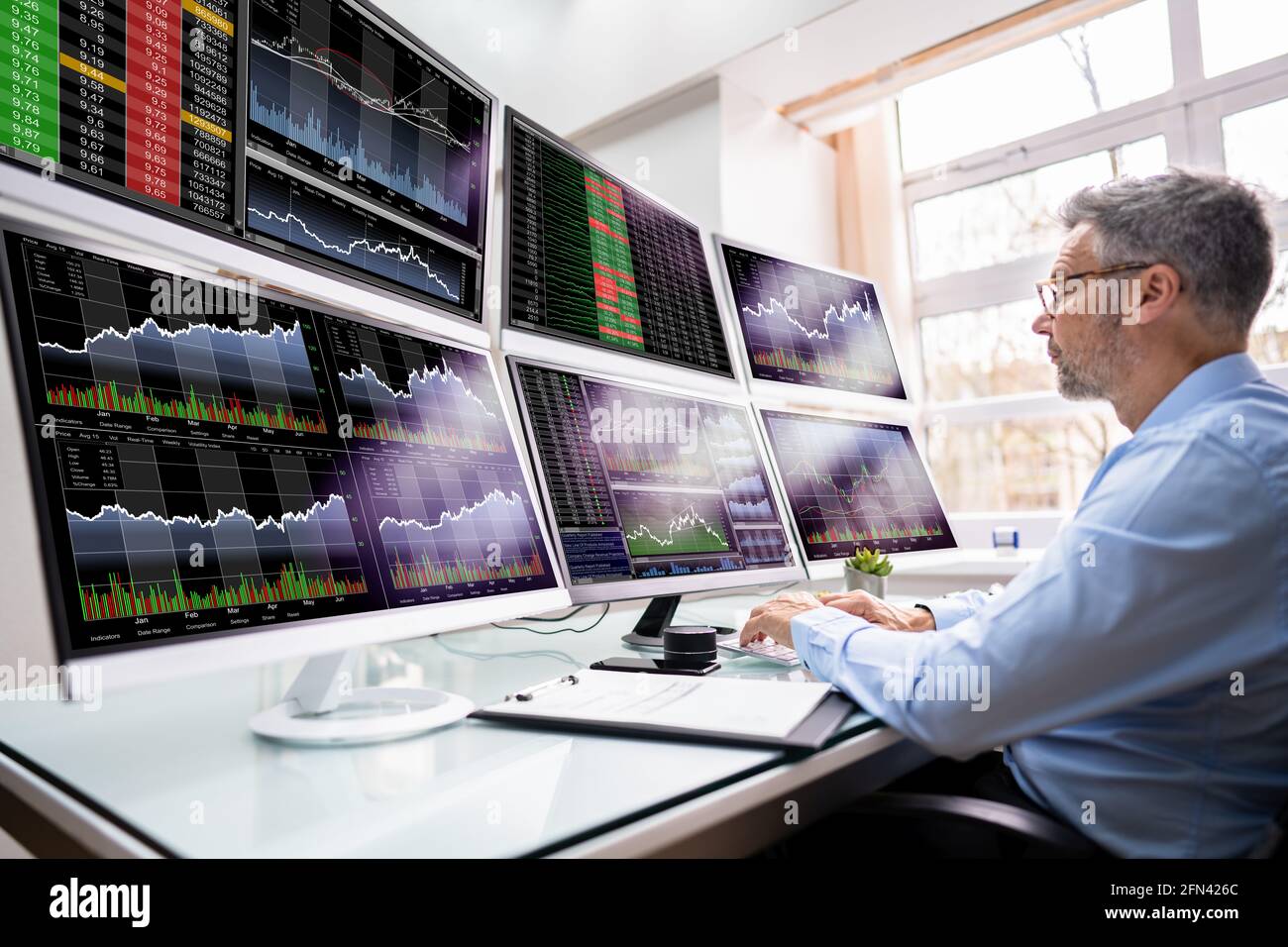 Stock Exchange Analyst Using Multiple Computer Screens Stock Photo - Alamy